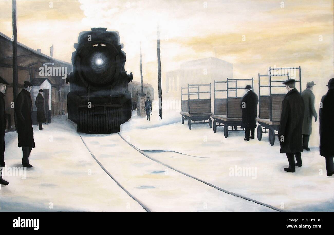 A locomotive pulls into a train yard as railway workers look on ...