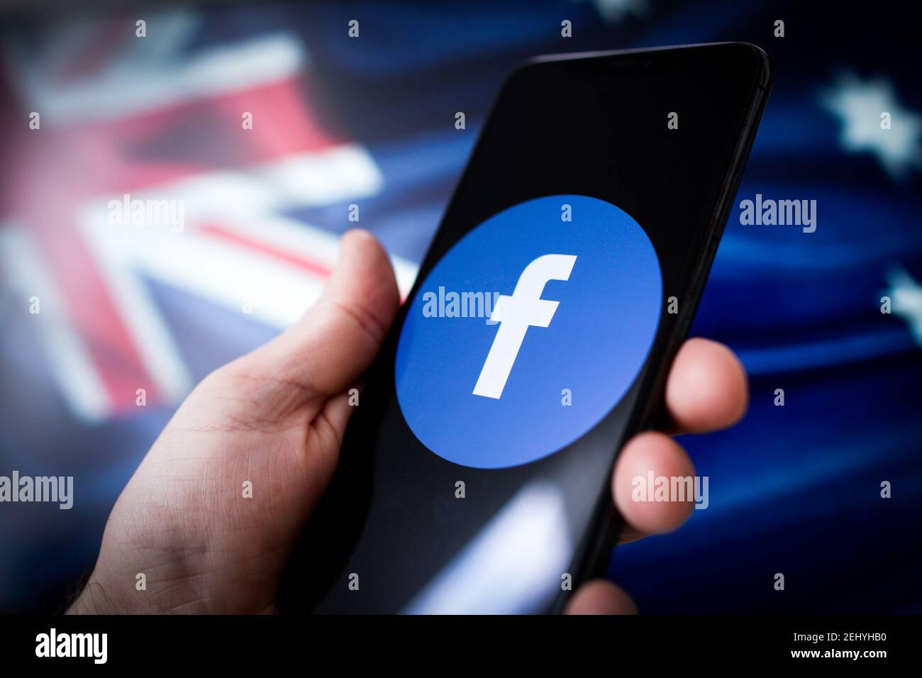The Facebook logo is seen with the Australian flag in the background in ...