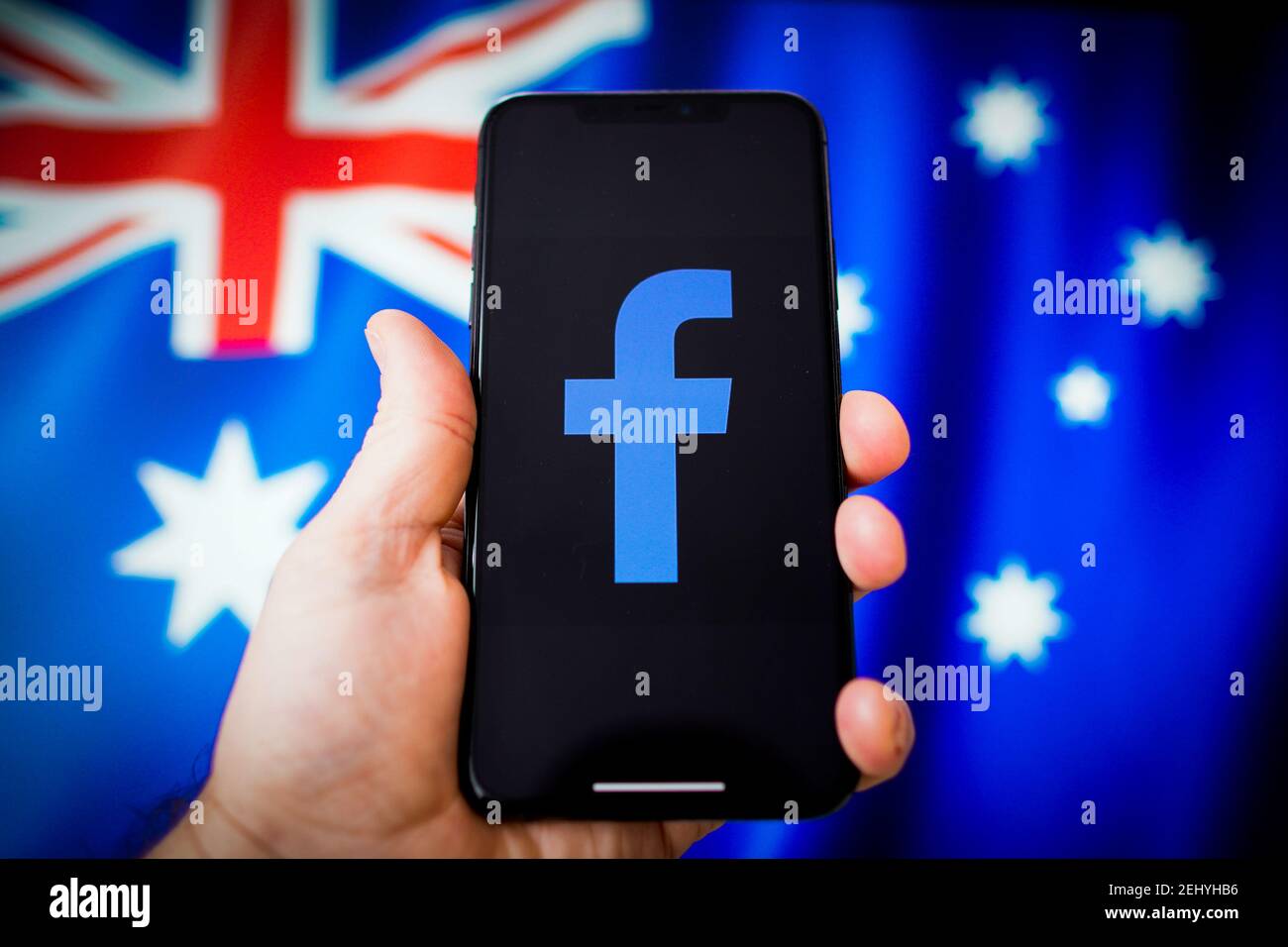 The Facebook logo is seen with the Australian flag in the background in ...