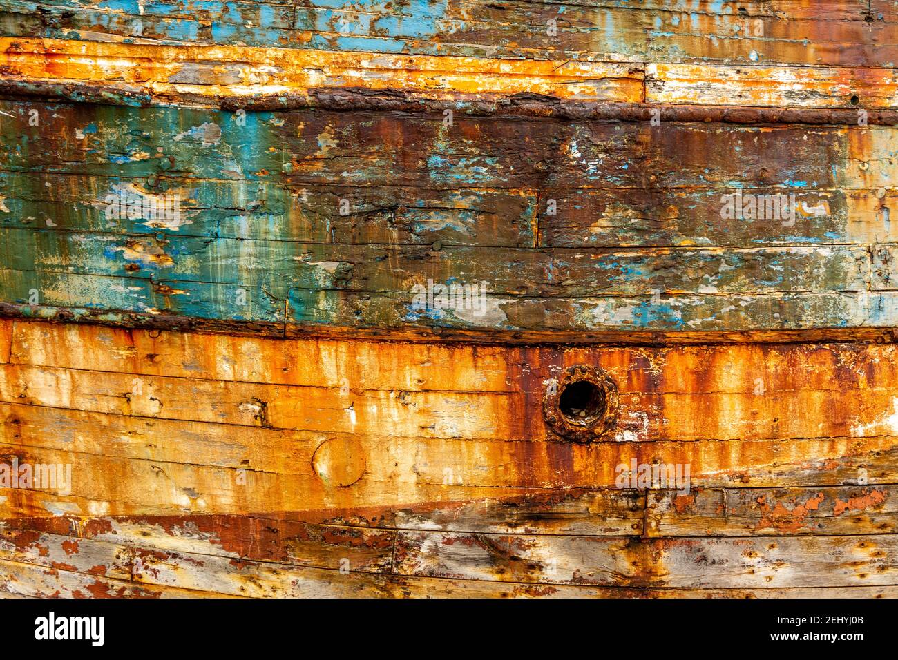 Rusting wooden fishing boat shows layers of color and wear in coastal ...