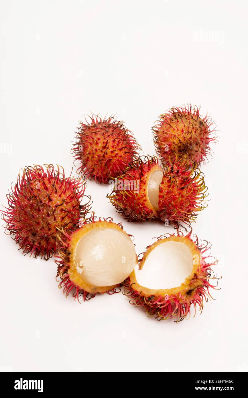 Fresh rambutan fruit displayed with open and closed varieties on a ...