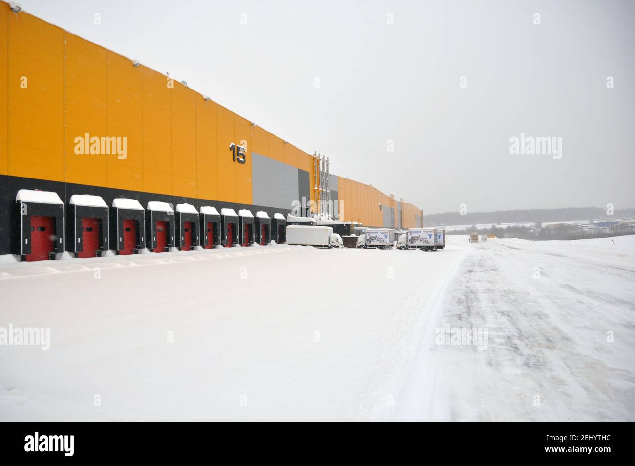 The empty loading bay of a large warehouse is covered with snow in ...