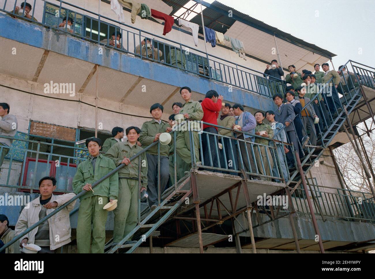 Chinese construction workers lined up in their dormitory waiting for ...