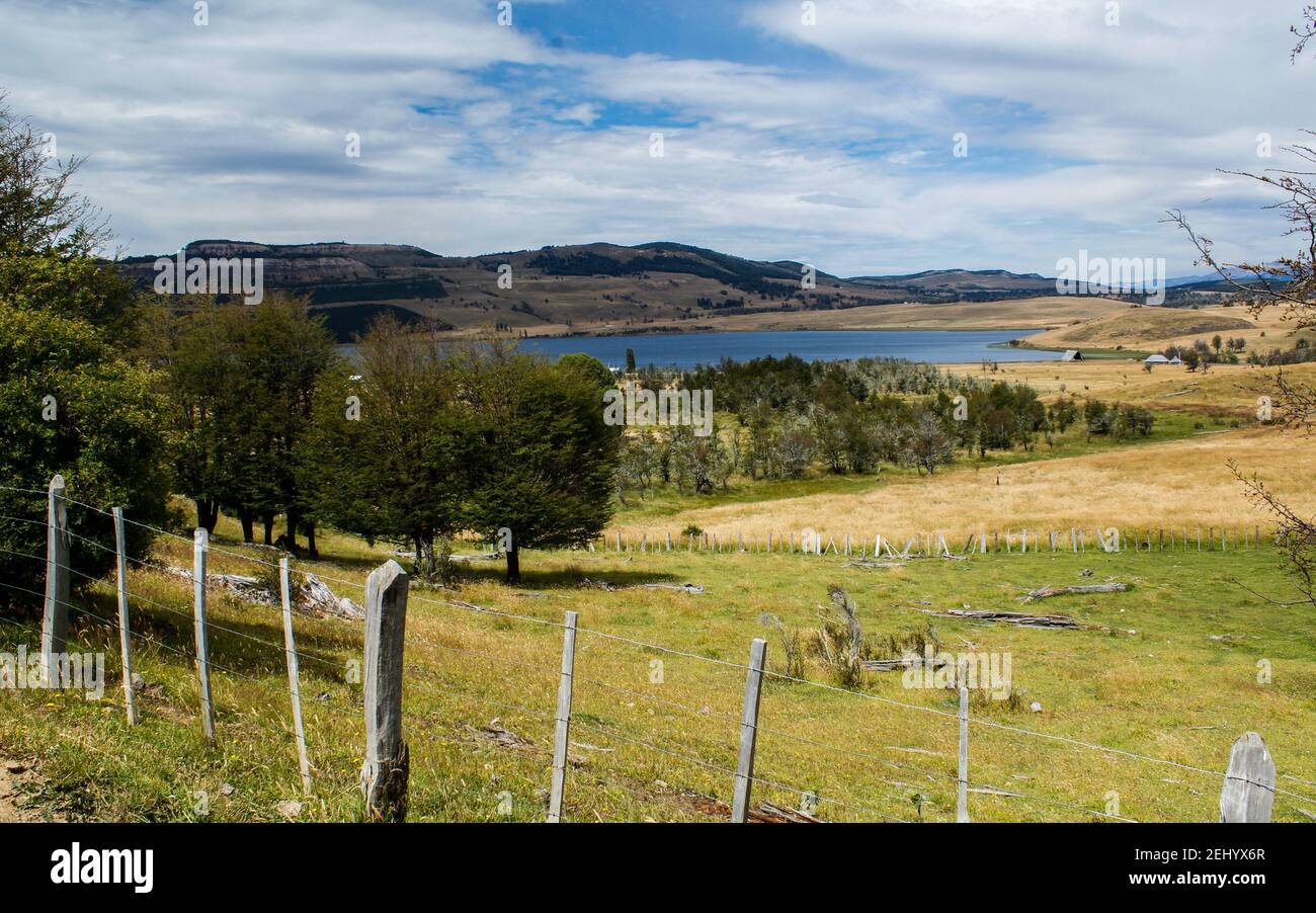 Farmland fence on lake and mountain background Stock Photo - Alamy