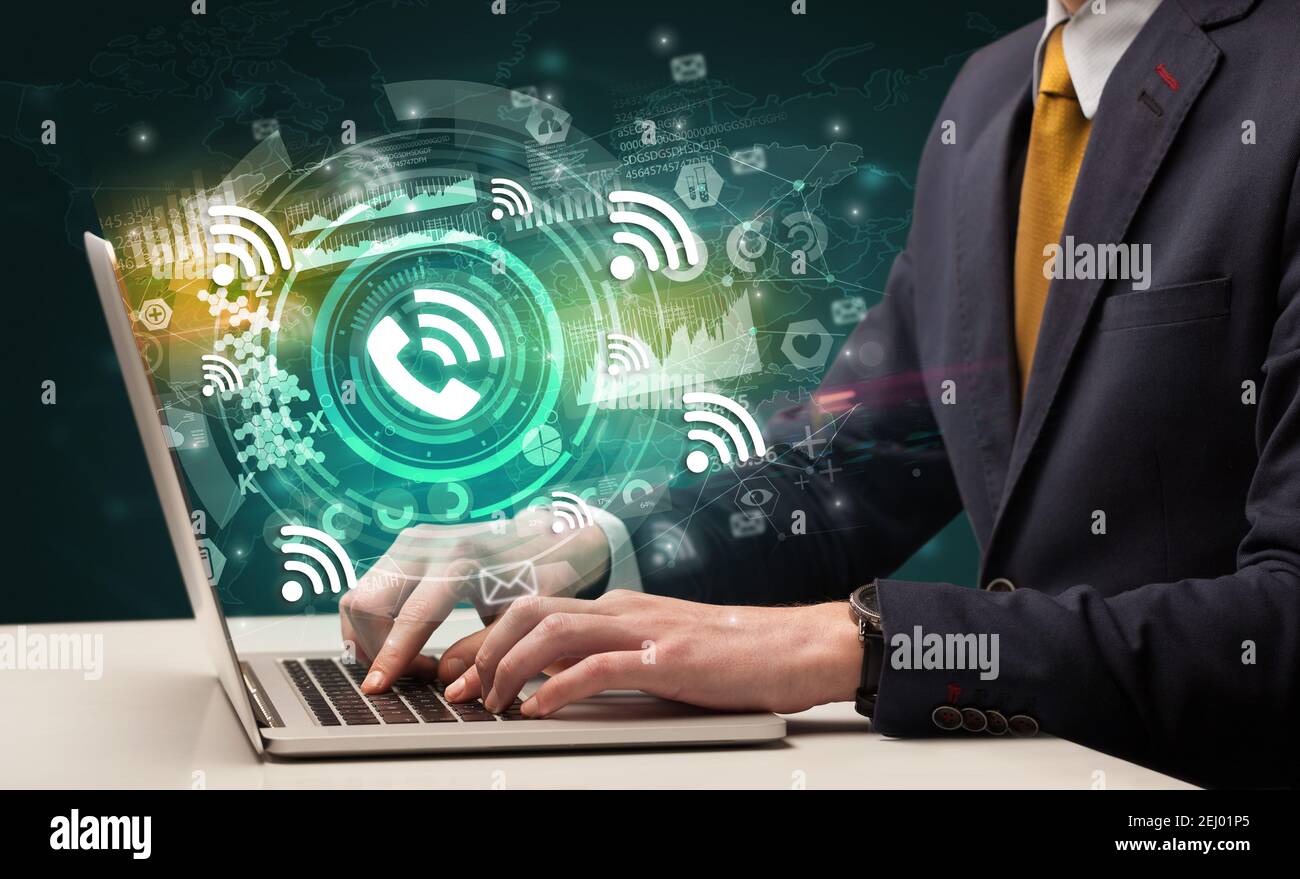 Business hand typing on a modern laptop with mobile signal icon coming ...