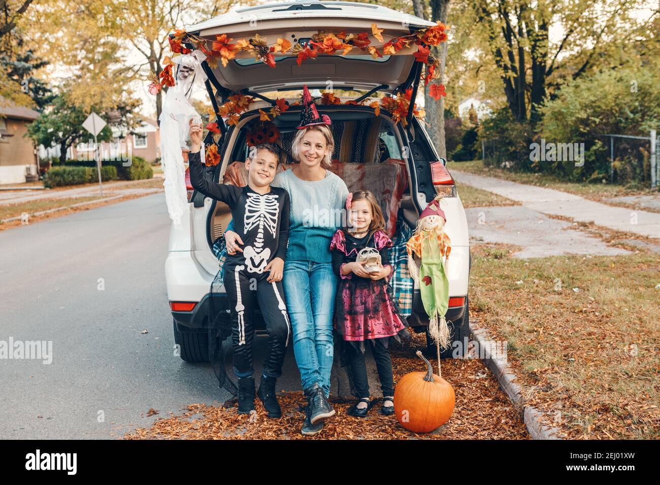 Trick or trunk. Family celebrating Halloween in trunk of car. Mother ...