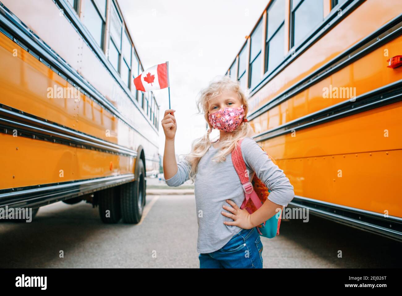 Caucasian girl student with face mask holding Canadian flag. Student ...