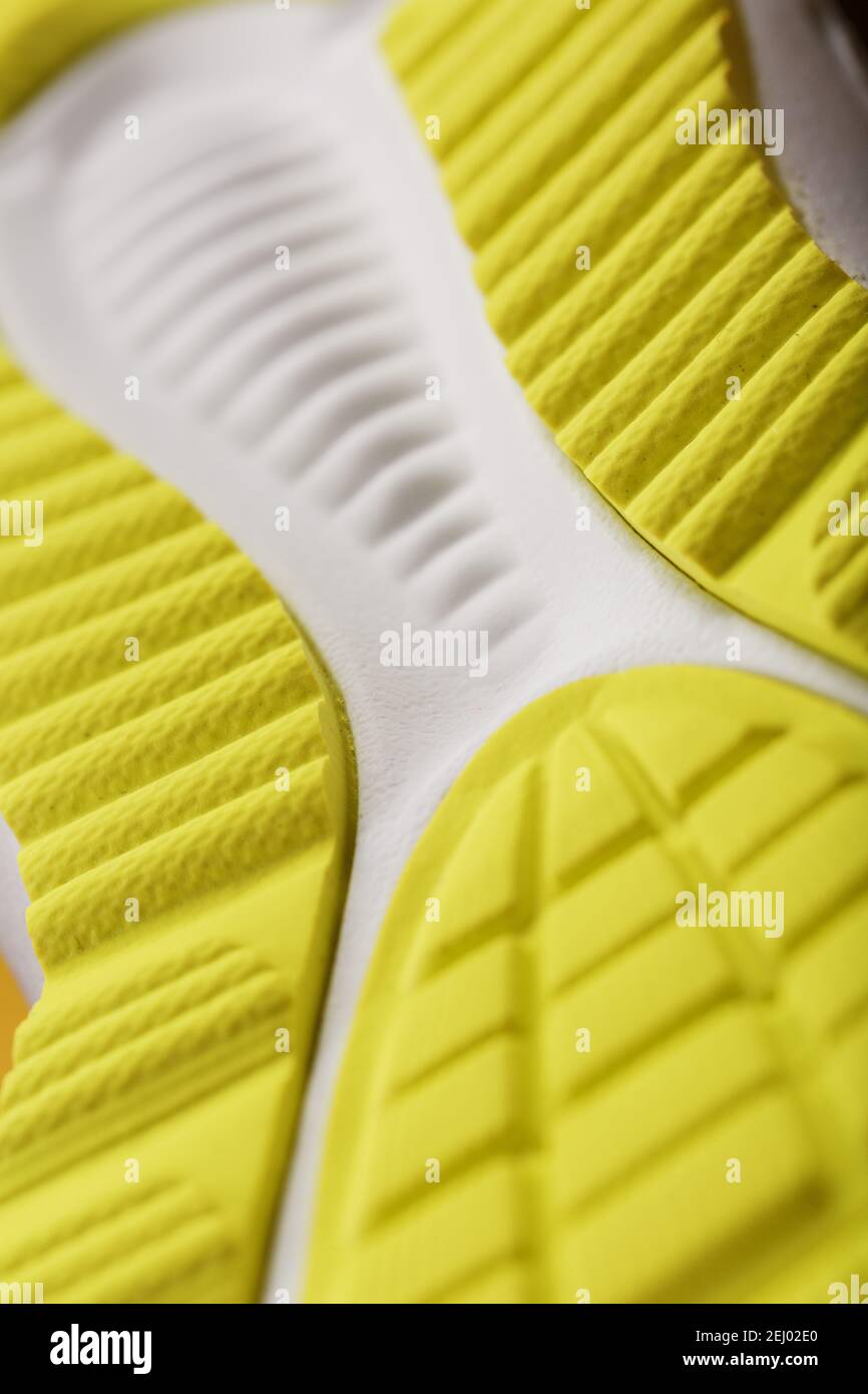 Close-up of the tread of a yellow sneaker, the textured pattern of the ...