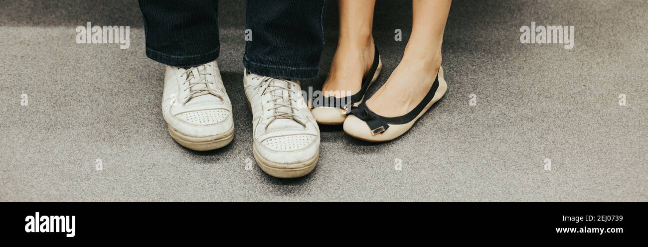 Closeup of man and woman legs in outdoor shoes together. Couple dating ...