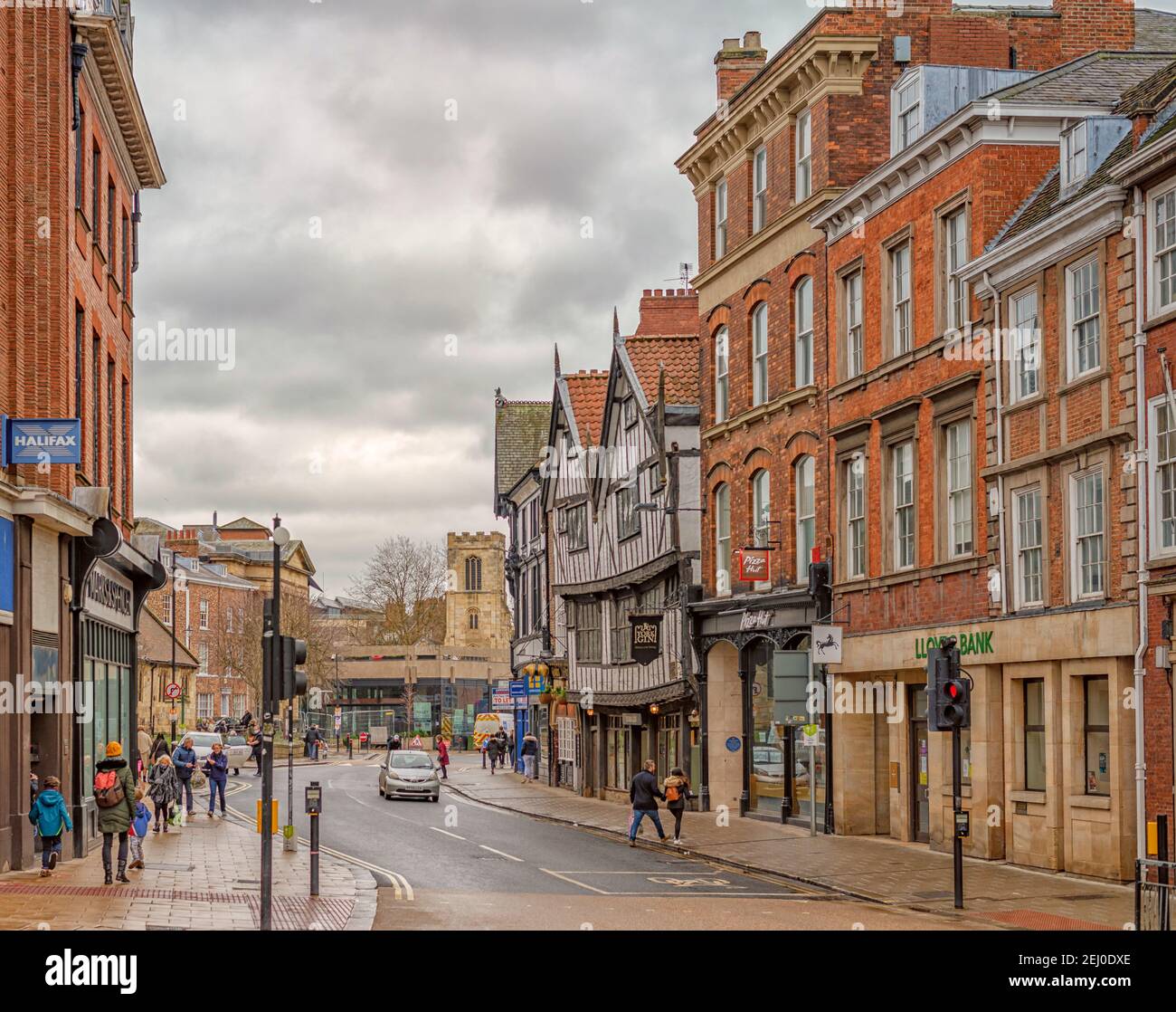 A street with ancient half-timbered historical buildings and a brick ...