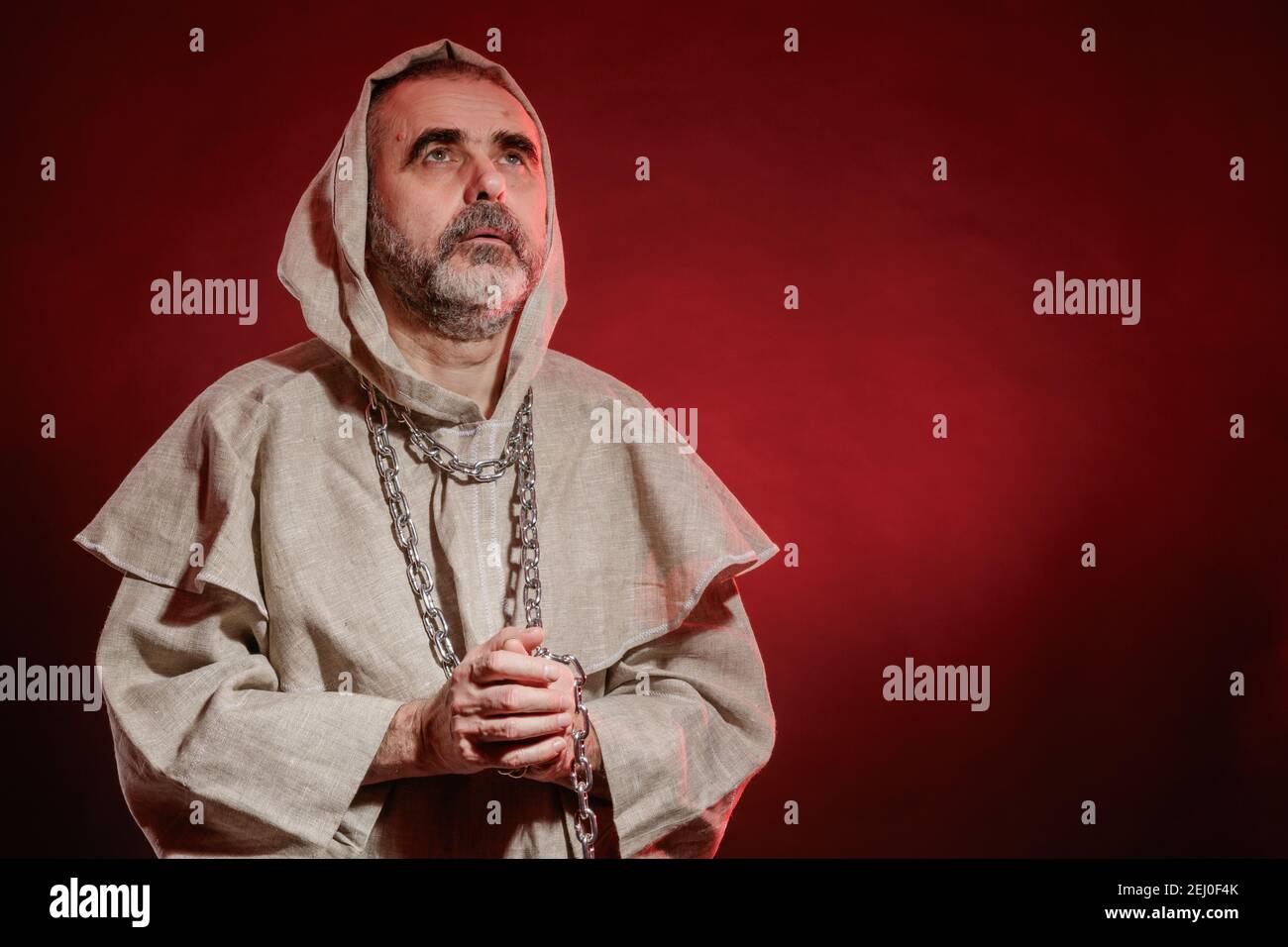 A wandering monk with a chain around his neck reads prayers Stock Photo ...