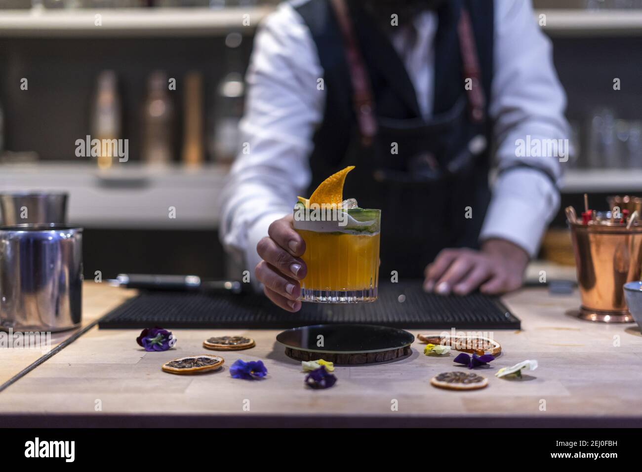 Selective shot of an expert barman holding a delicious cocktail at a ...