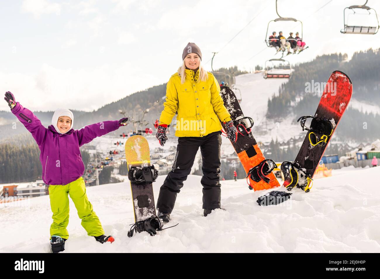 mother and daughter with snowboards at winter resort Stock Photo - Alamy