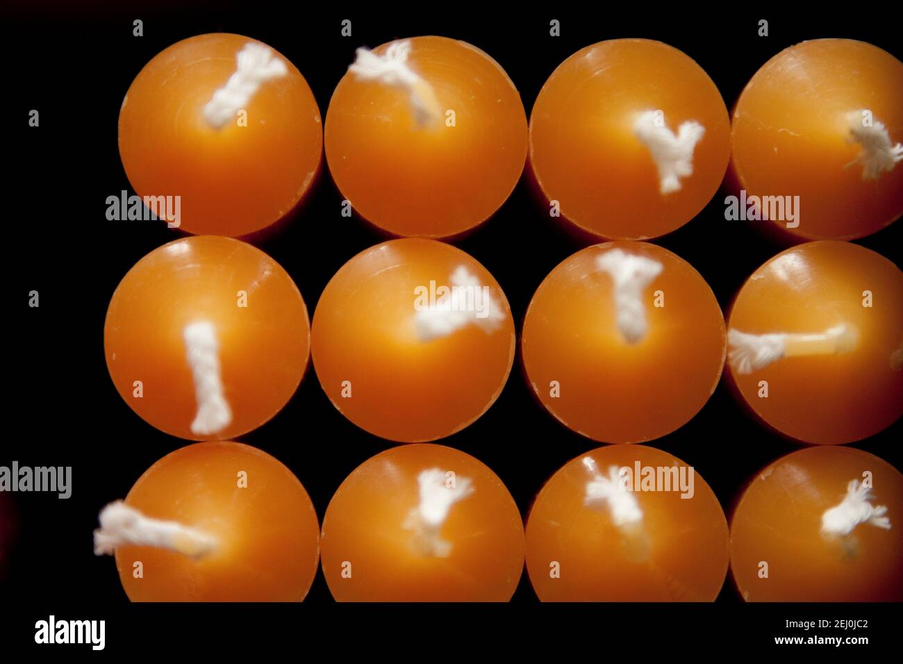 Overhead view of unlit orange candles on a black background Stock Photo ...