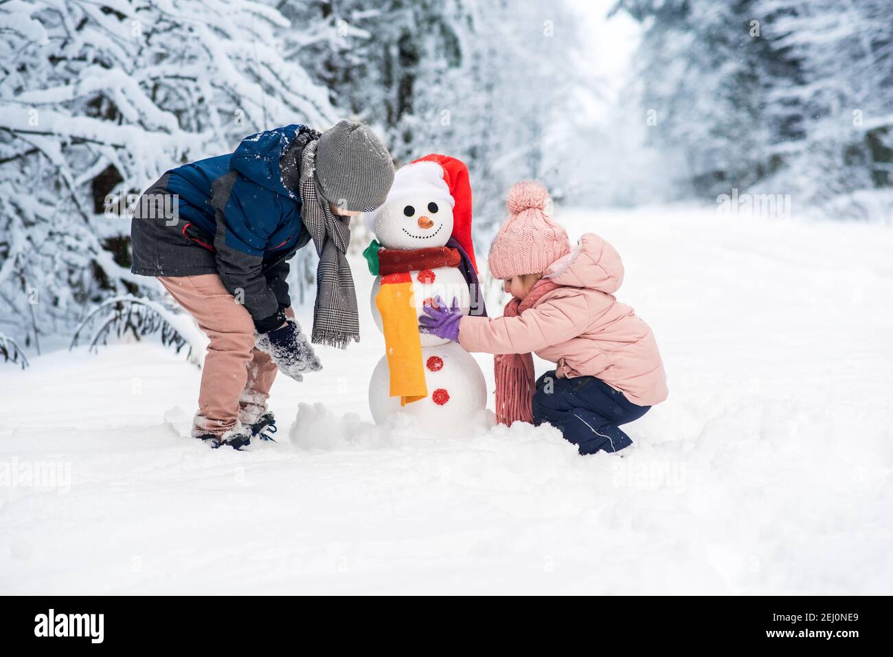 Family building snowman together in hi-res stock photography and images ...