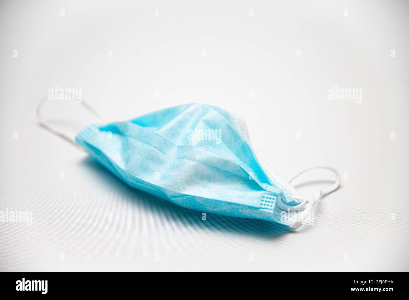 Single-use mask on a white surface - covid19, pandemic, quarantine ...