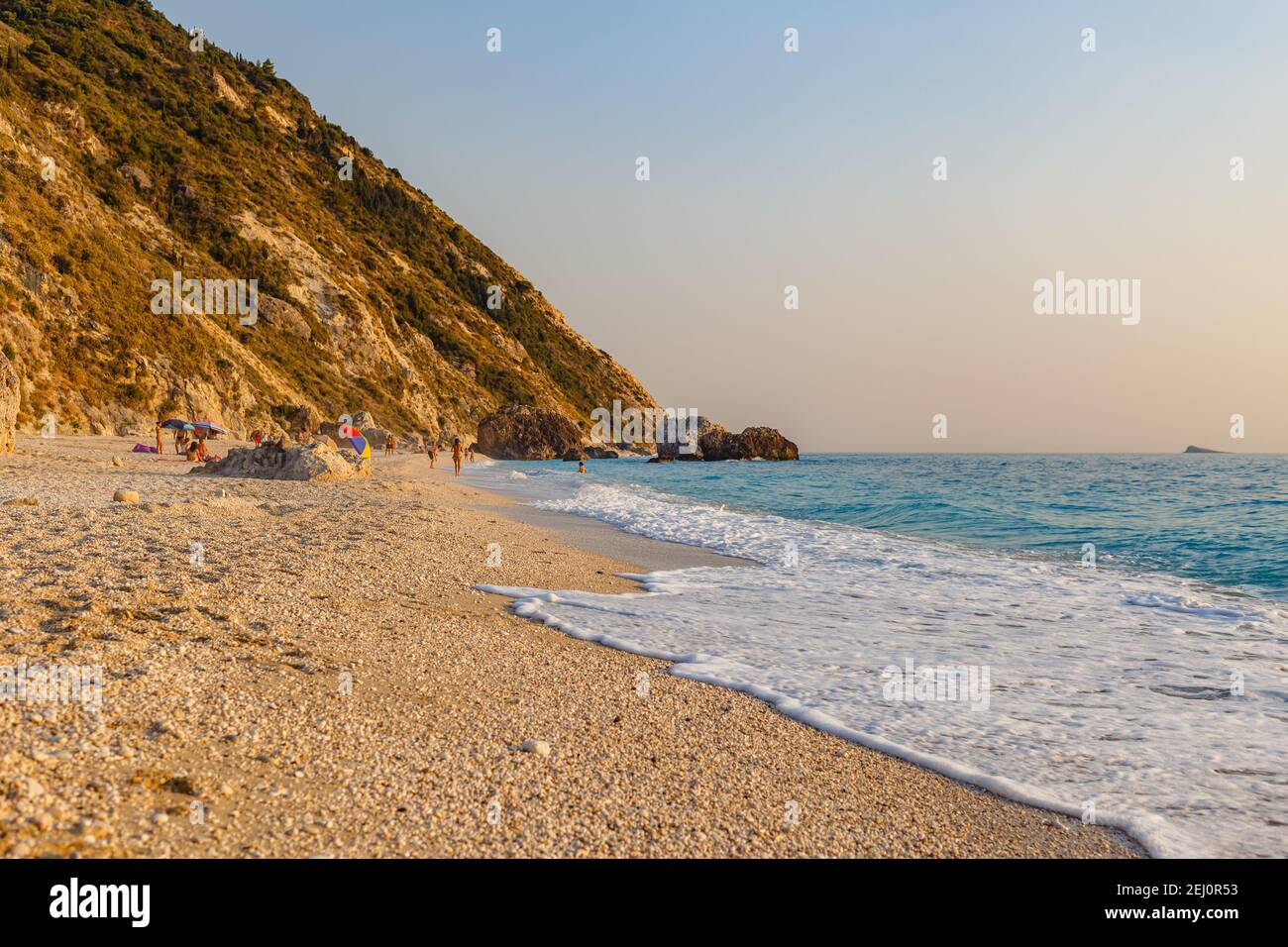 Wavy beach with people spending time on background of a cl Stock Photo ...