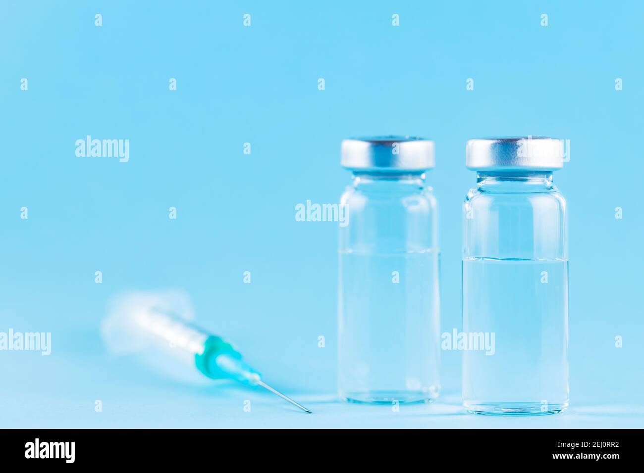 Vaccine and syringe injection. Vaccines and syringe on a blue ...