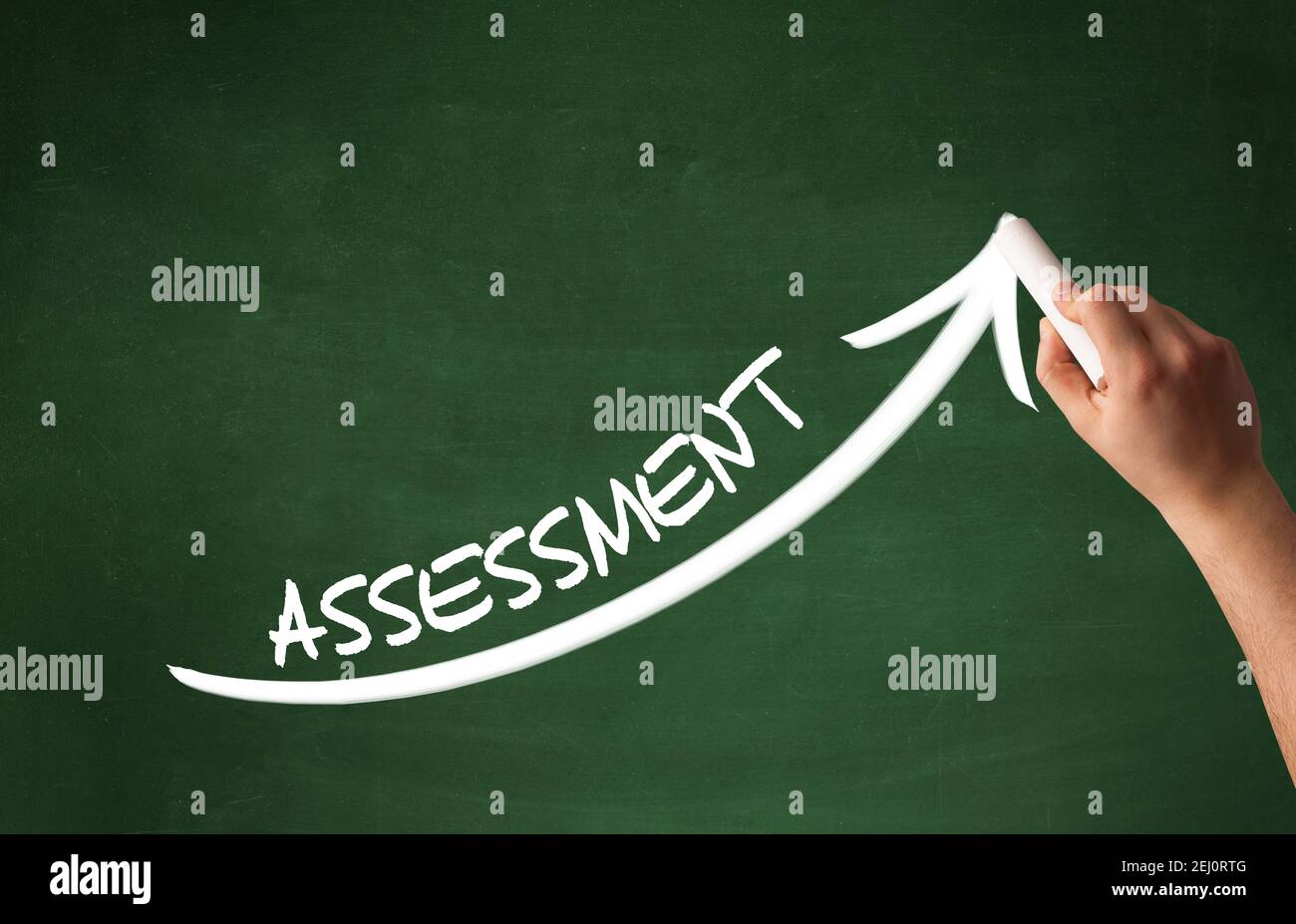 Hand drawing ASSESSMENT inscription with white chalk on blackboard ...