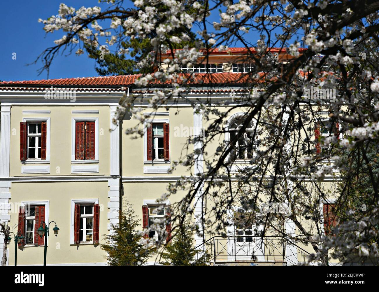 Neoclassical public building facade with stucco walls, red wooden ...