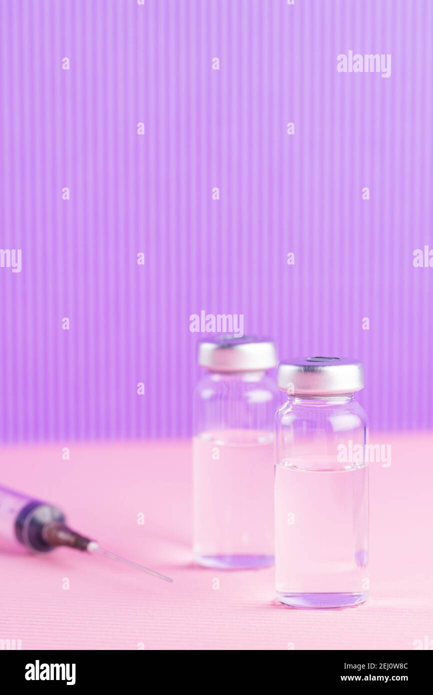 Vaccines and syringe on a pink purple background for prevention and ...