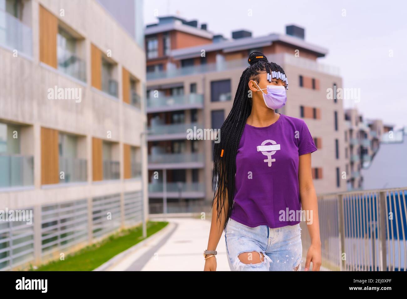 Attractive Native American female walking in the city wearing a mask ...