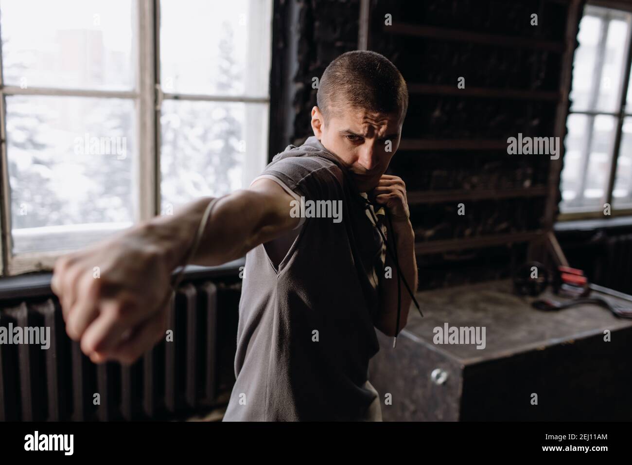Cool man fighter in boxing bandages trains in the gym. Mixed martial ...