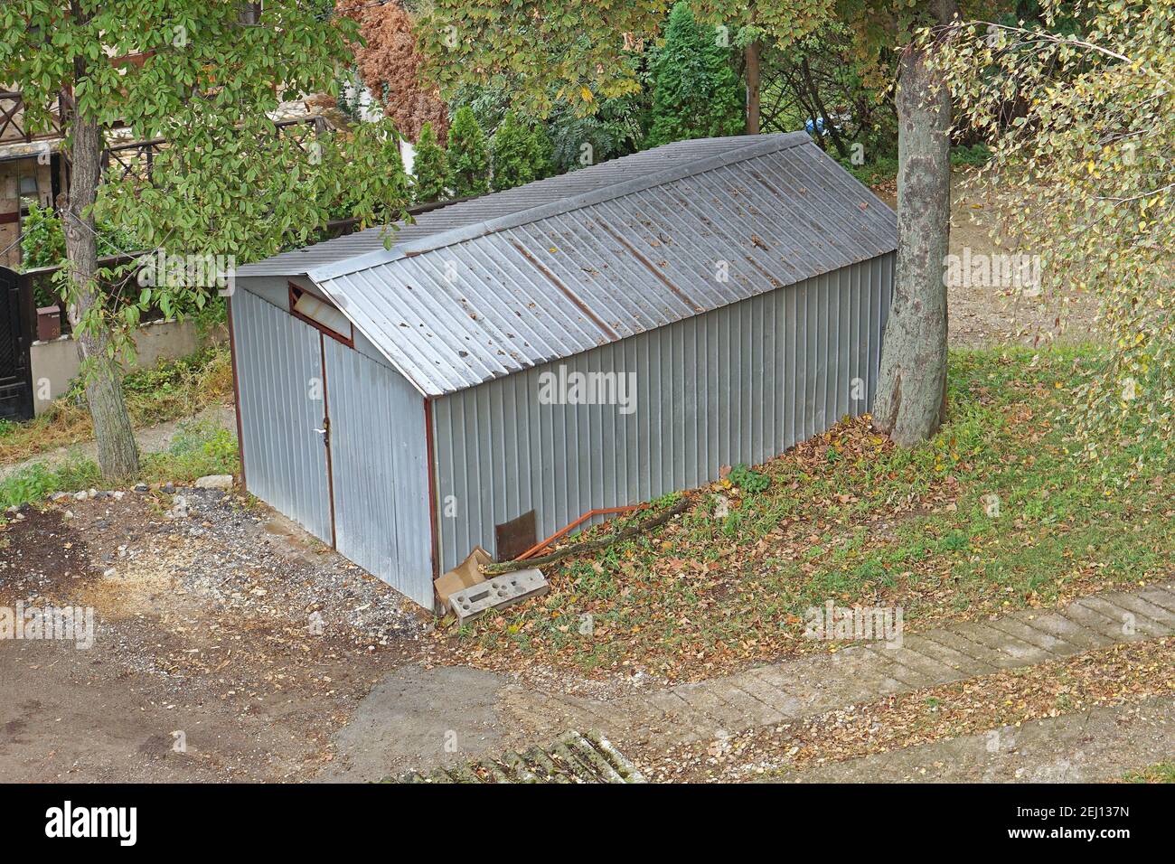 Metal shed garage structure hidden in woods Stock Photo - Alamy