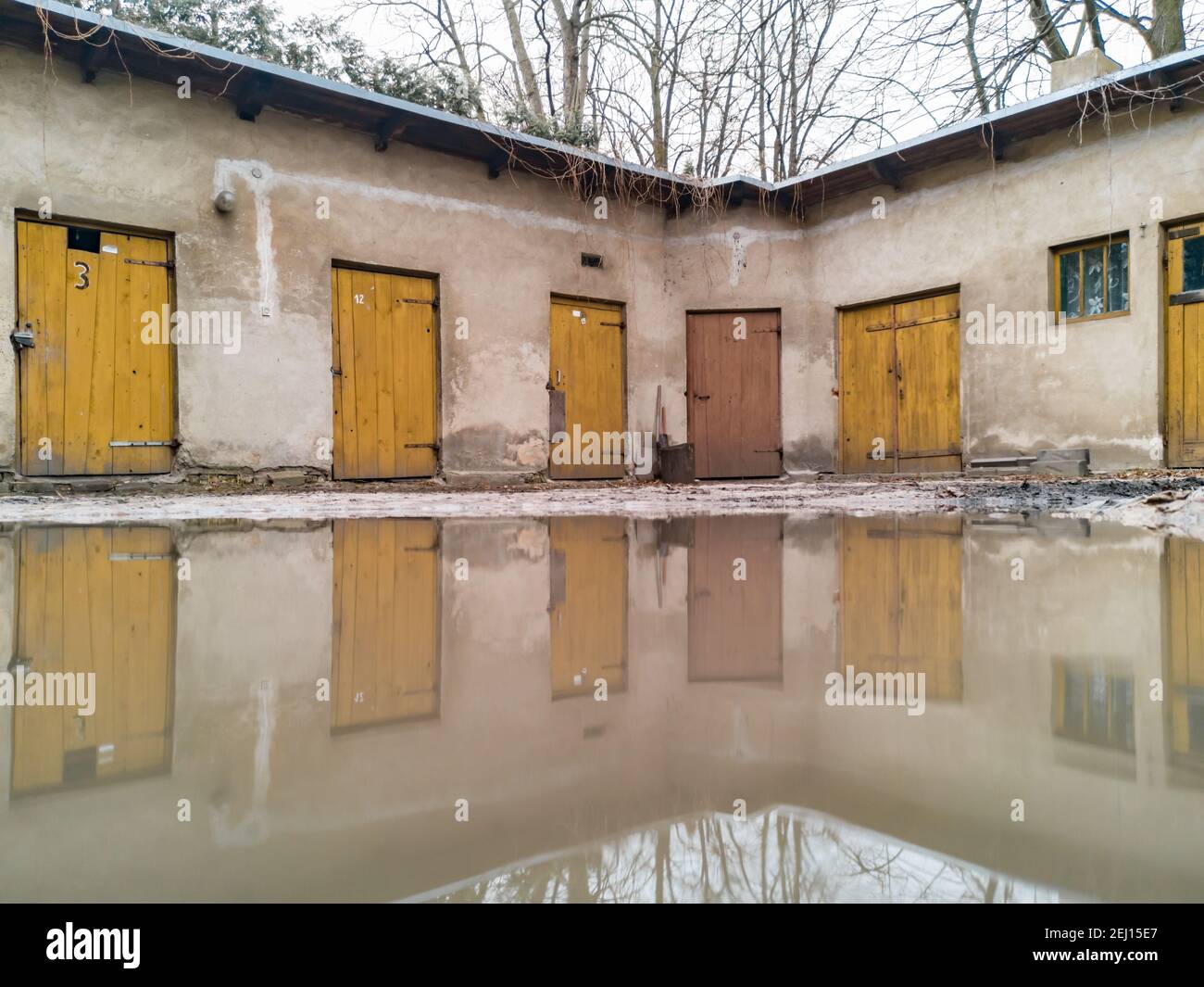Small building with few doors reflected in small puddle Stock Photo - Alamy