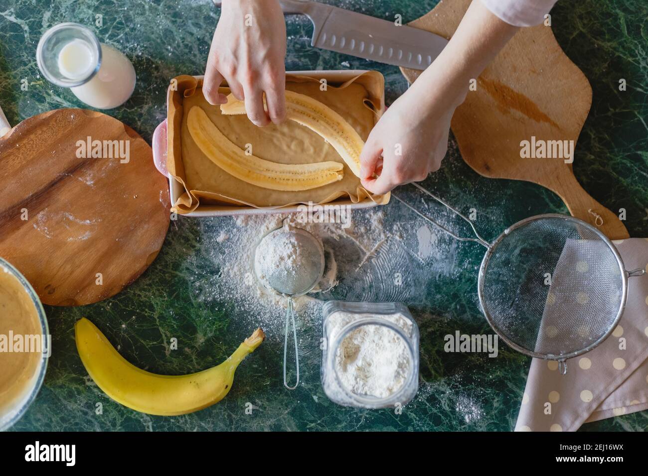 The girl puts the cut banana for the filling into the pie dough. Top ...