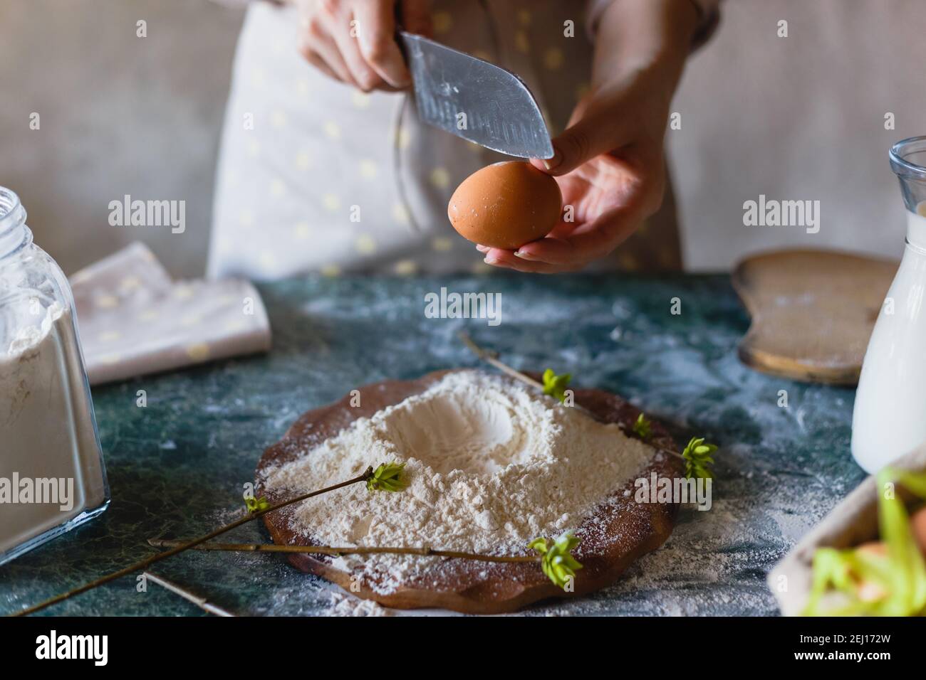 Breaking an egg with a knife into a hill of flour. Cooking baking ...
