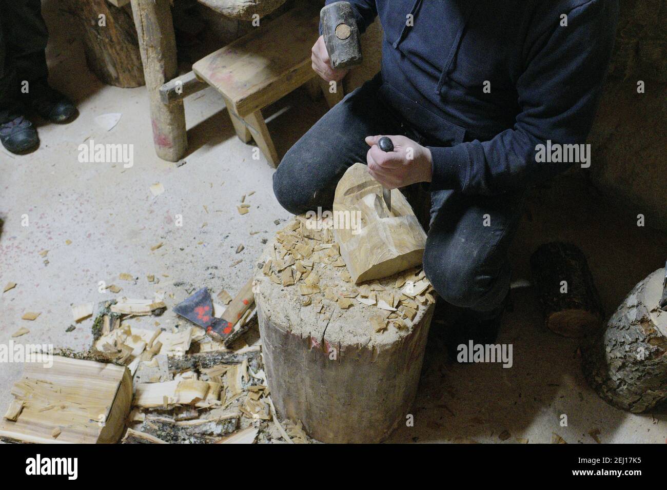 Mask builder in his workshop, carving traditional masks used in the ...