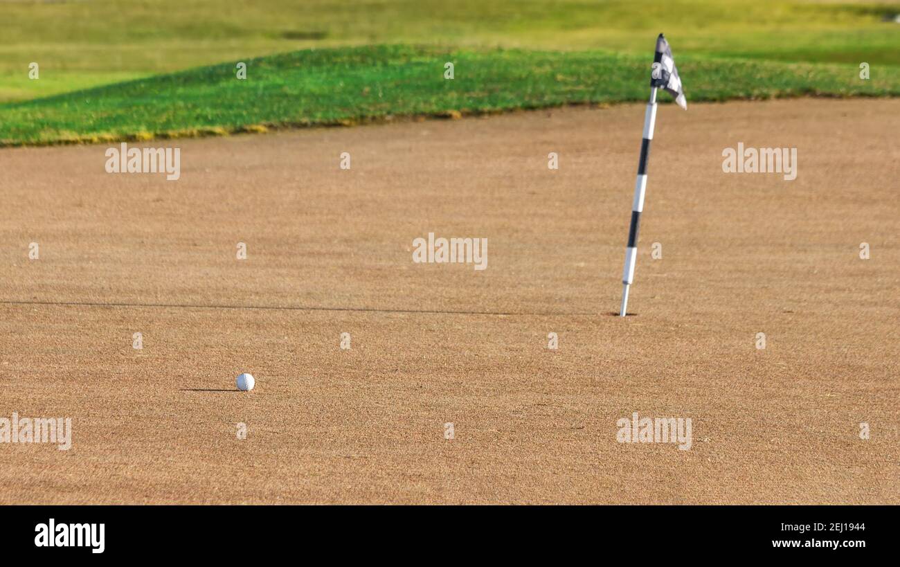 Empty golf field with a ball close to the hole, in it there is a ...
