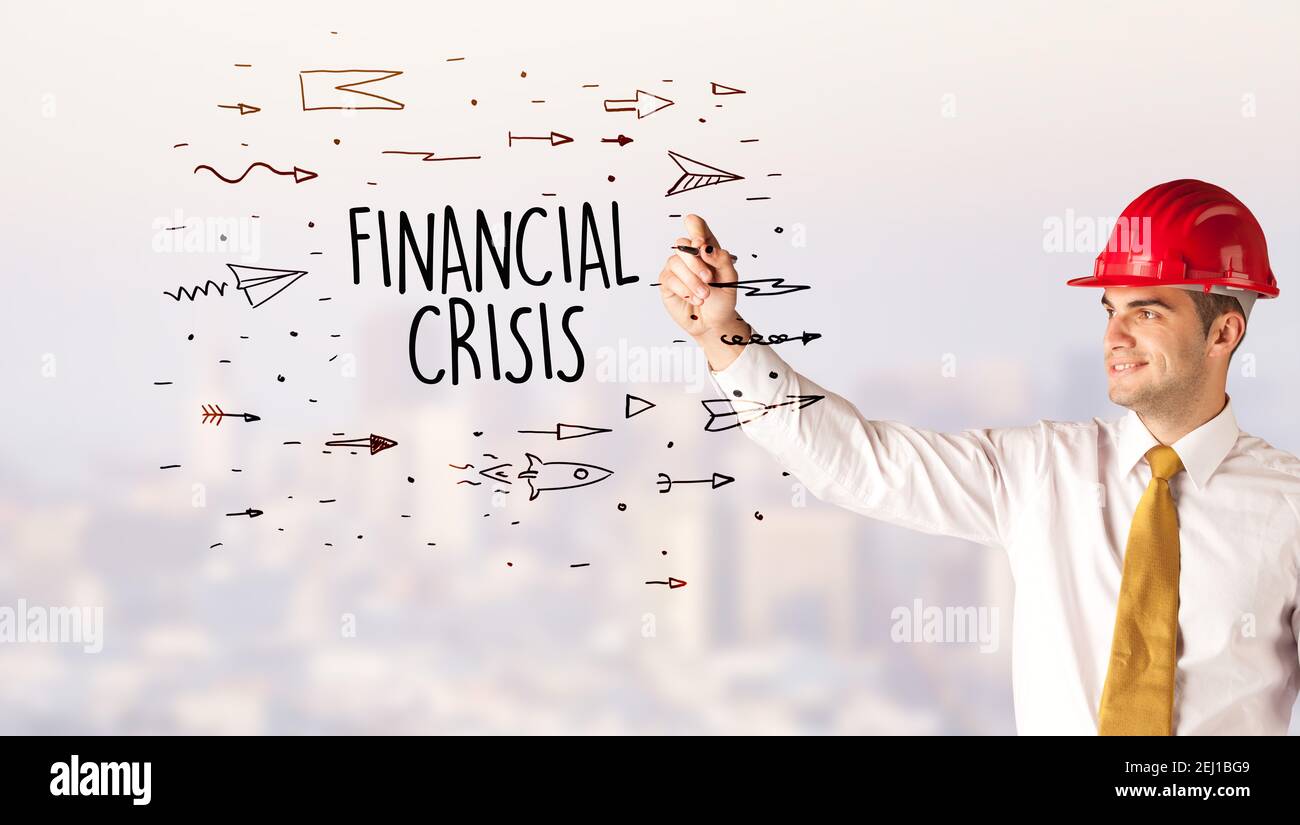 Handsome businessman with helmet drawing FINANCIAL CRISIS inscription ...
