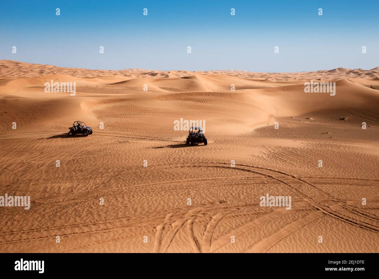 Beautiful landscape of arabic desert sand dunes with two riding quad ...
