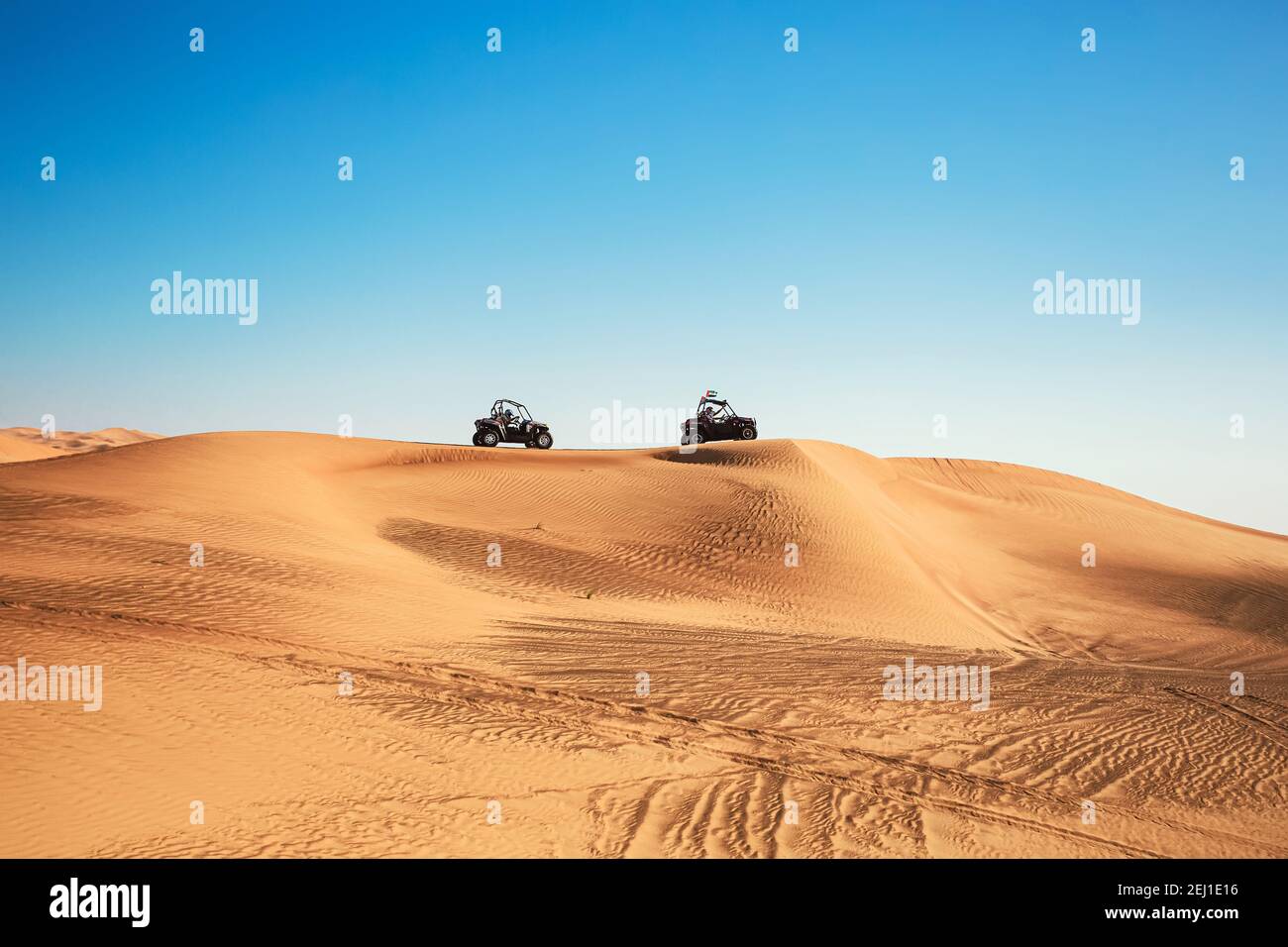 Two buggy quad bikes riding at bright Al Awir (Aweer) desert landscape ...