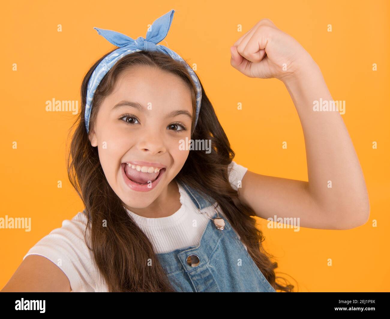 I did it. Happy little girl flex biceps on yellow background. Girls ...