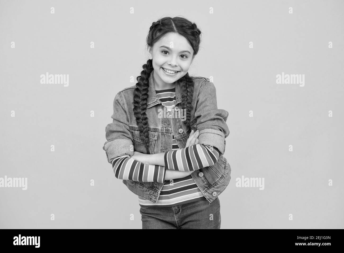 Cheerful little girl with braids wear denim clothes, fancy teen concept ...