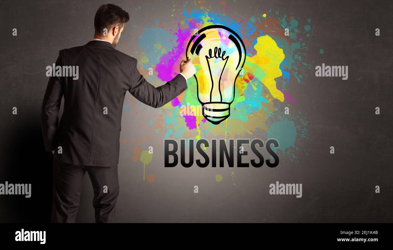 businessman drawing colorful light bulb with BUSINESS inscription on ...