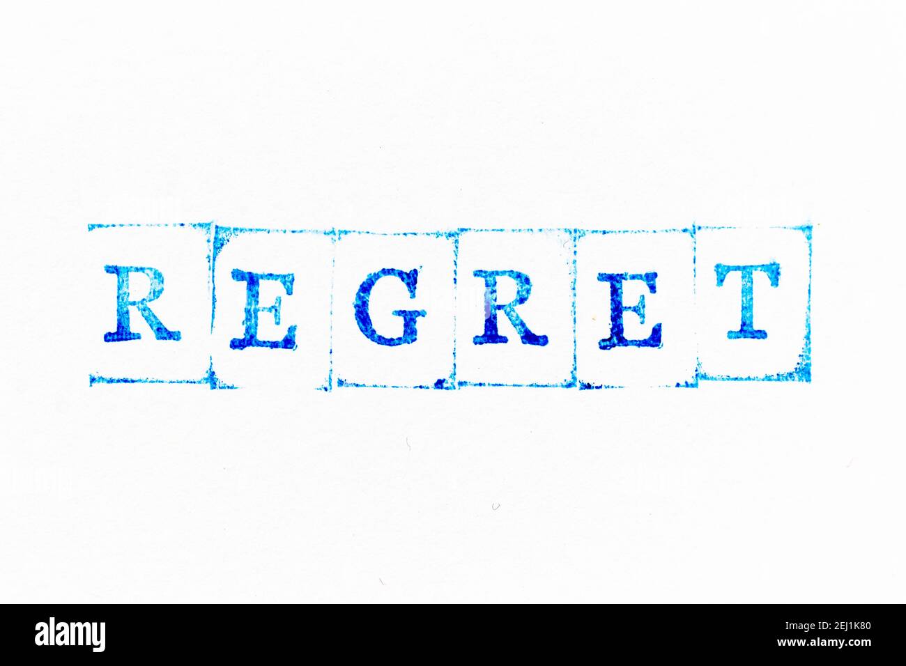 Blue color ink rubber stamp in word regret on white paper background ...