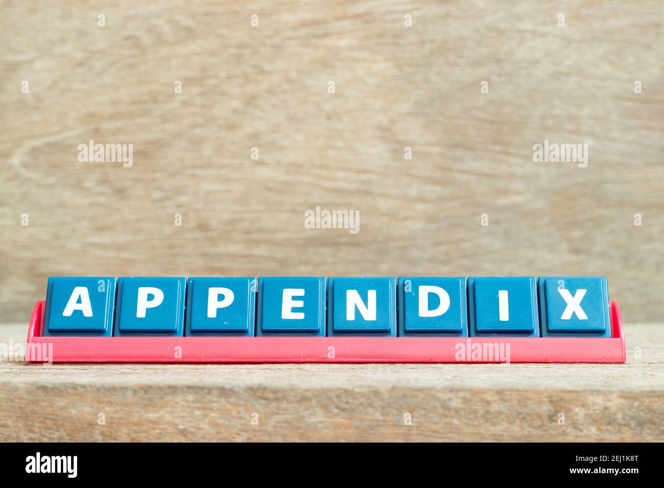 Tile alphabet letter with word appendix in red color rack on wood ...