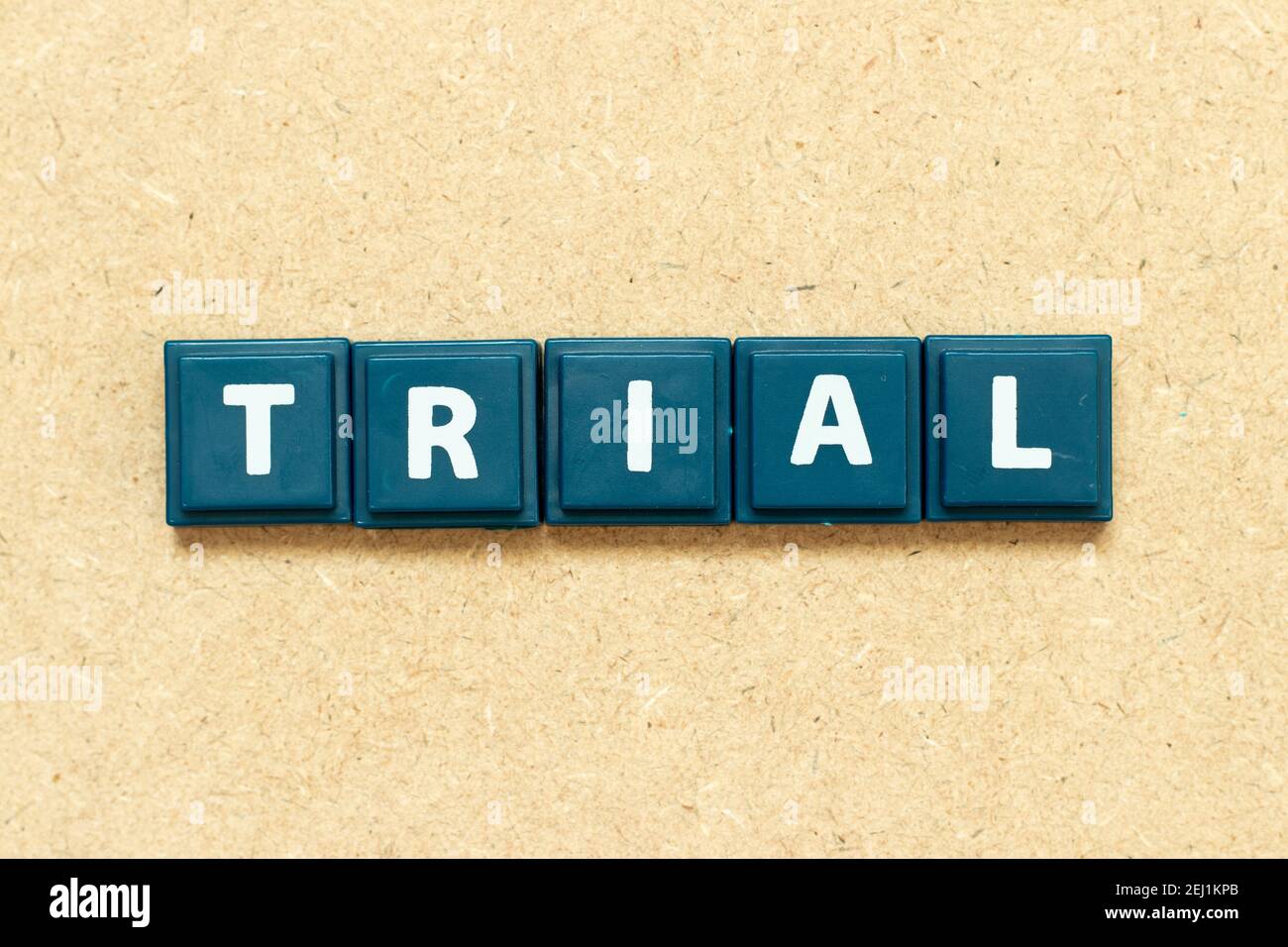 Tile alphabet letter in word trial on wood background Stock Photo - Alamy