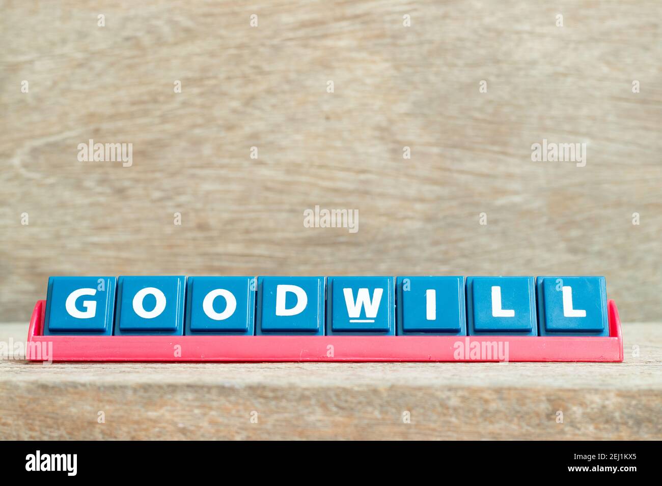 Tile alphabet letter with word goodwill in red color rack on wood ...
