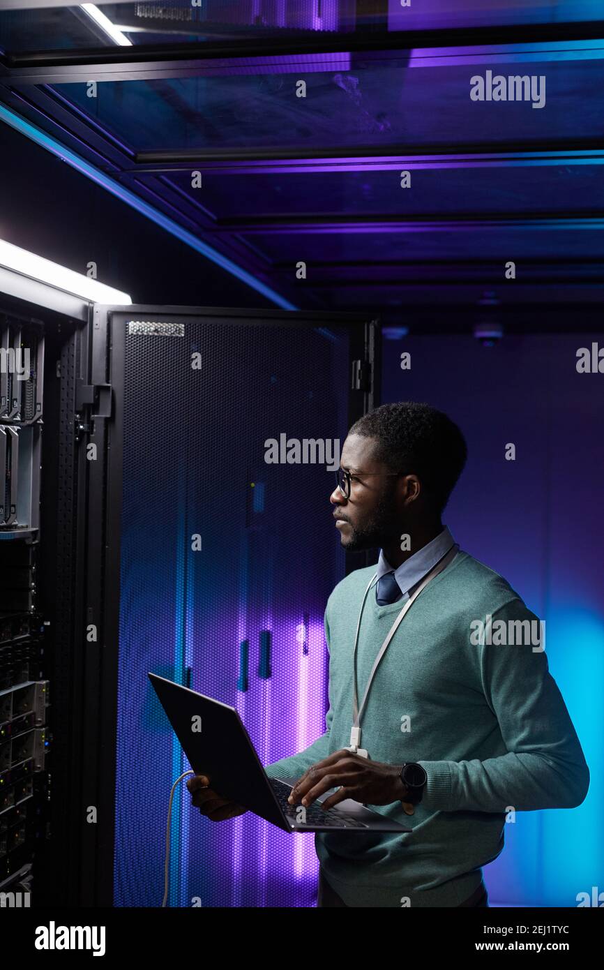 Vertical portrait of young African American data engineer holding ...