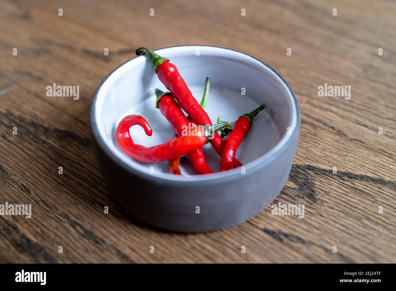 red cayenne peppers in a small white circle bowl Stock Photo - Alamy