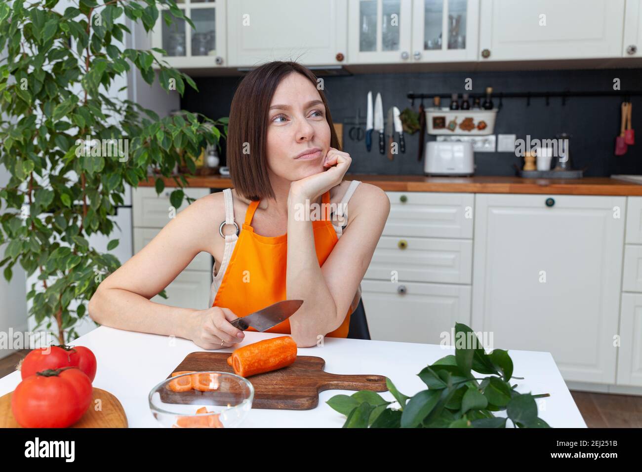 Young beautiful woman sitting at kitchen background while cooking Stock ...