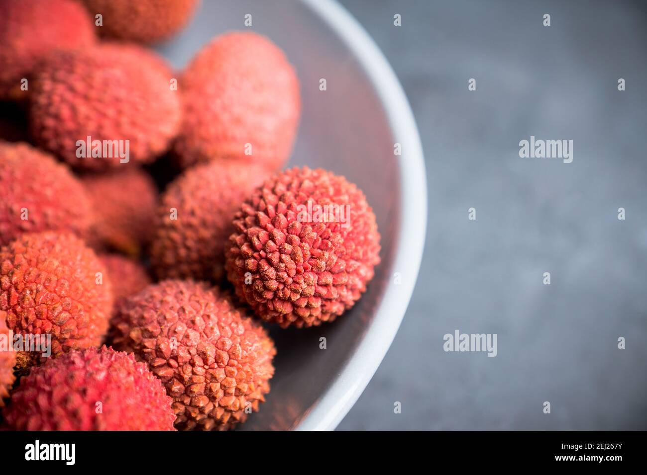 Red ripe lychees on the rustic background. Selective focus. Shallow ...
