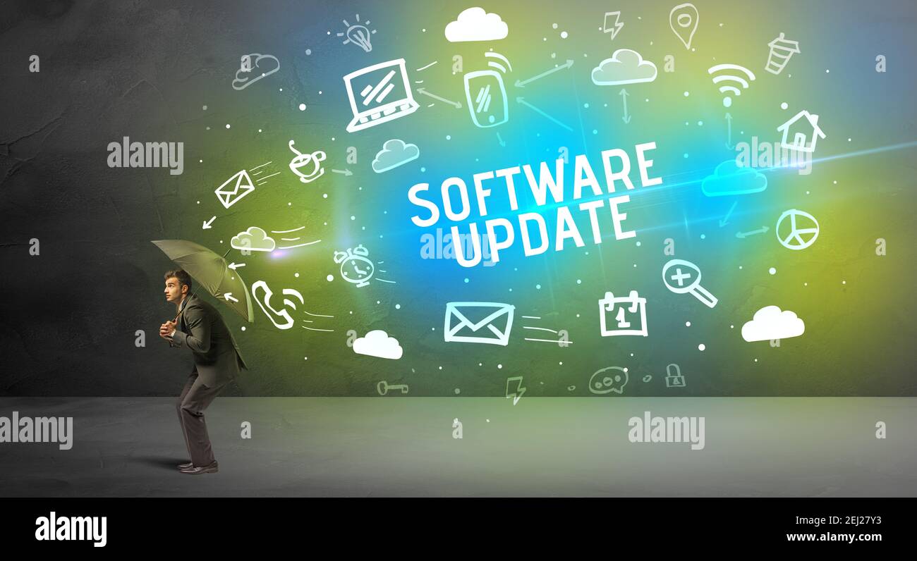 Businessman defending with umbrella from SOFTWARE UPDATE inscription ...