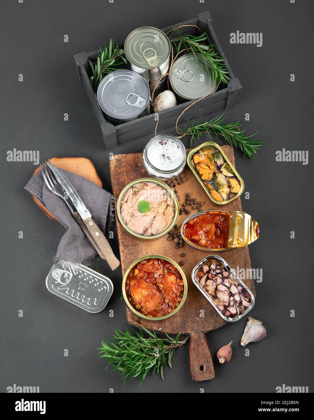 Various canned fish and seafood in aluminum cans. On dark gray ...