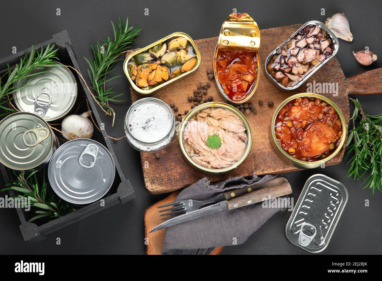 Various canned fish and seafood in aluminum cans. On dark gray ...